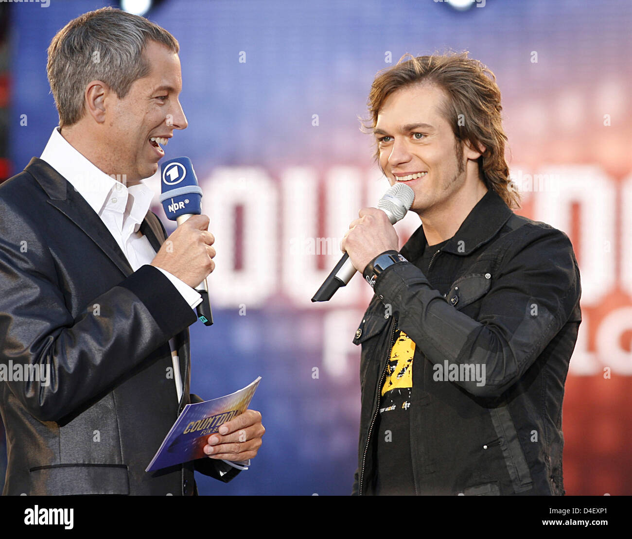 Tv presenter Thomas Hermanns (L) talks to the winner of the tv show ...