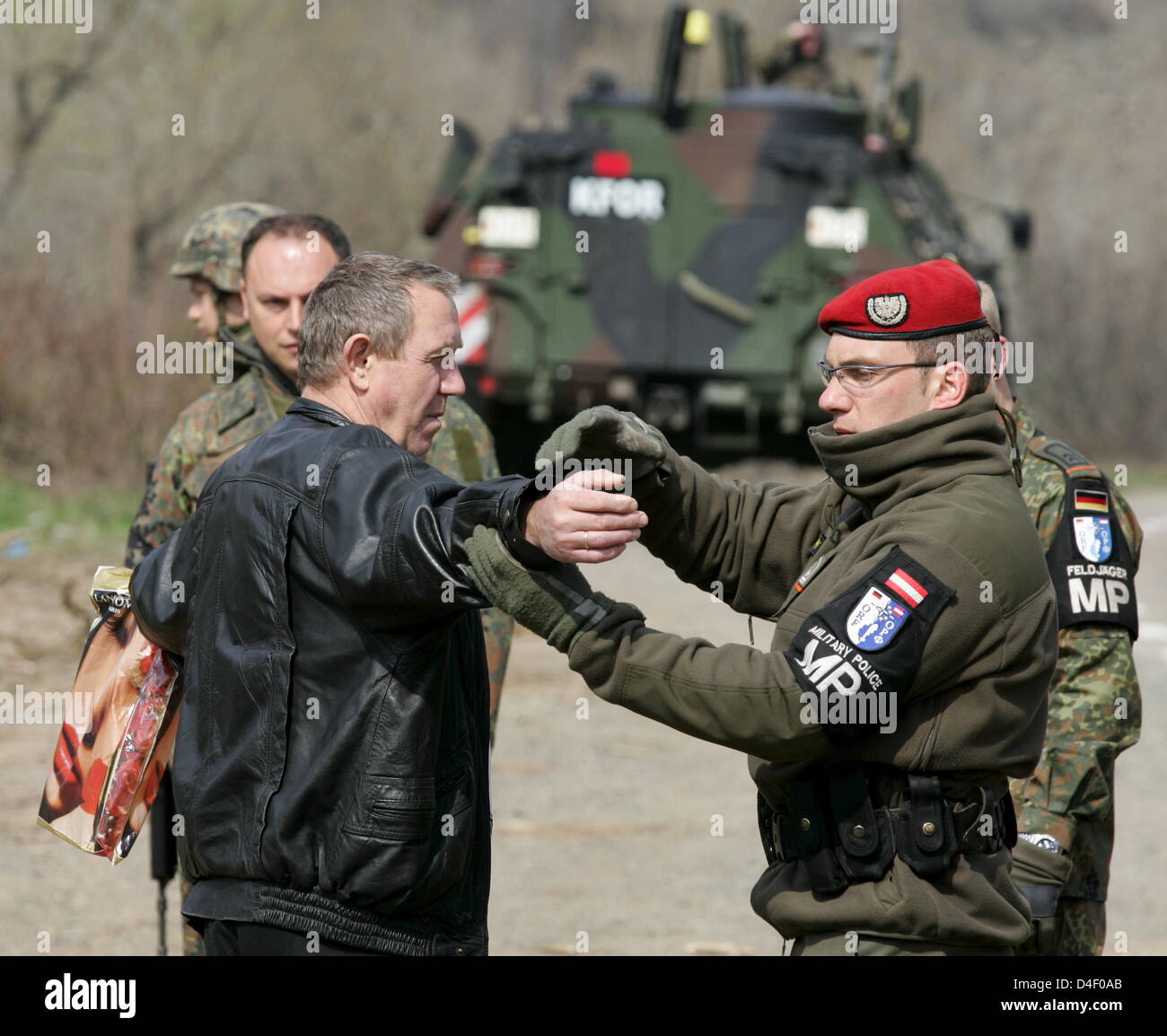 Soldiers of German Bundeswehr and Austrian Military Police inspect a ...