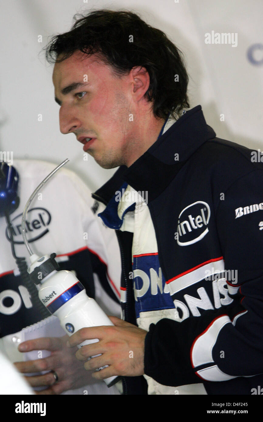 Polish Formula One driver Robert Kubica of BMW Sauber talks to a team ...