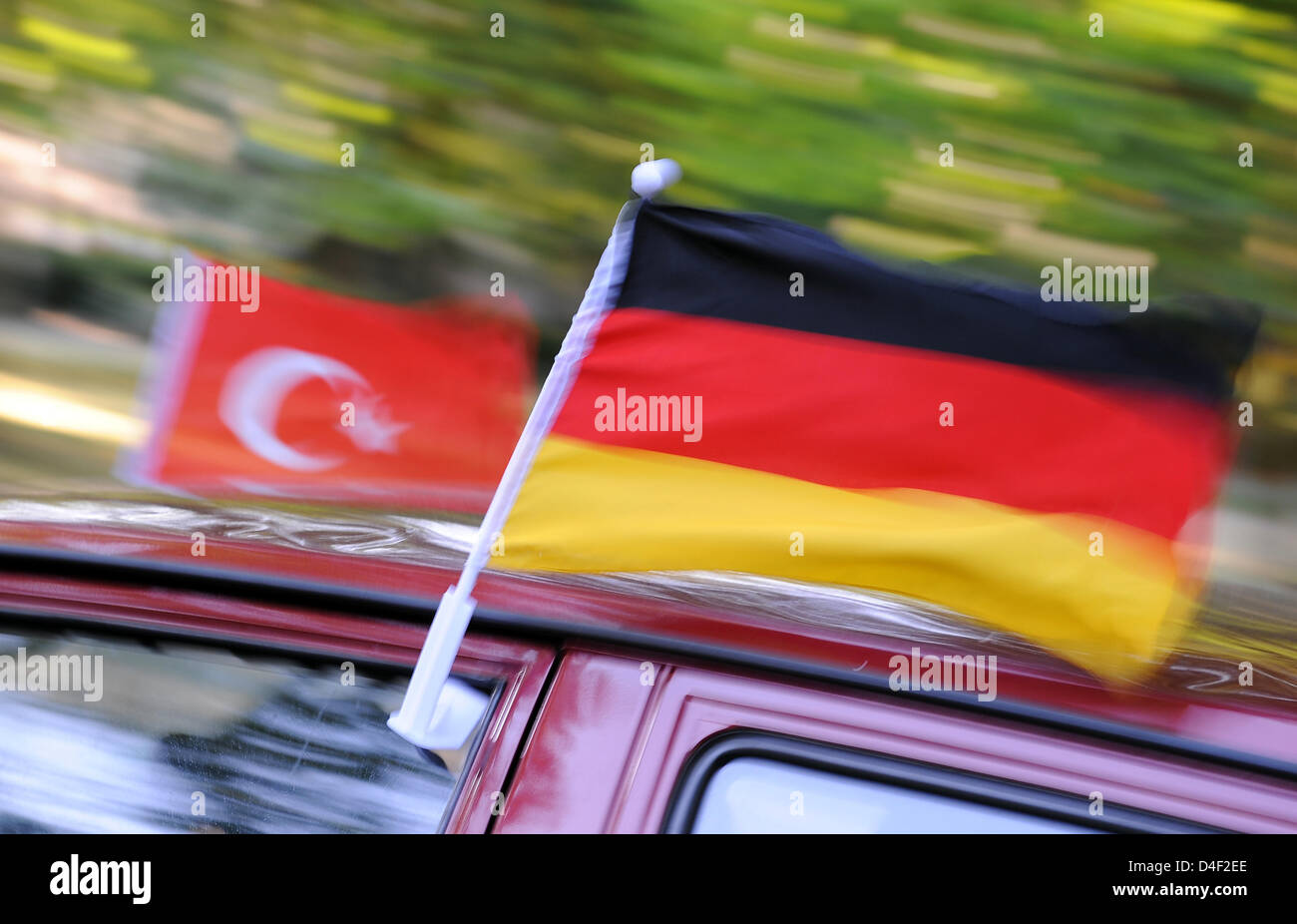 A Turkish soccer fan with a German and a Turkish national flag attached ...