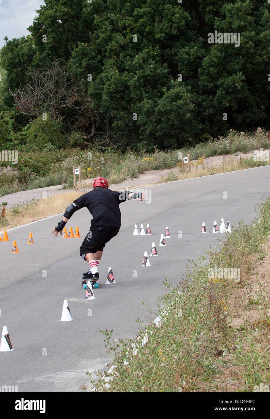 Skateboarder competing in a downhill skateboard slalom at the Redbridge ...