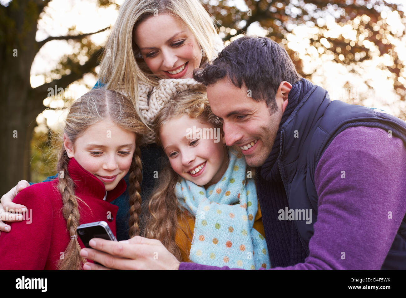 Family using cell phone outdoors Stock Photo - Alamy