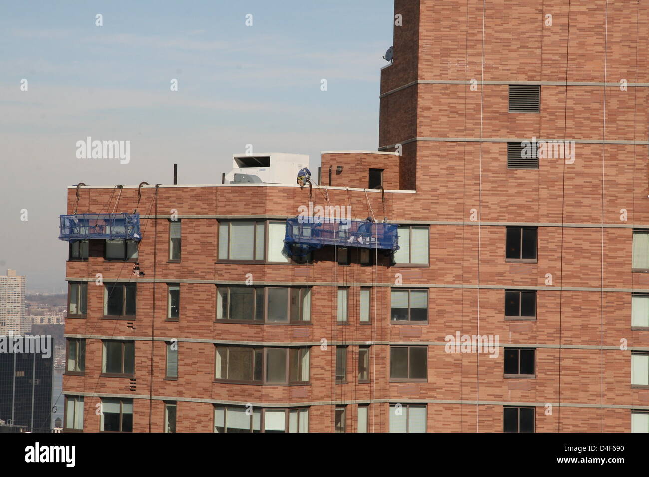 Workers do maintenance work on a high rise building in Manhattan, New ...