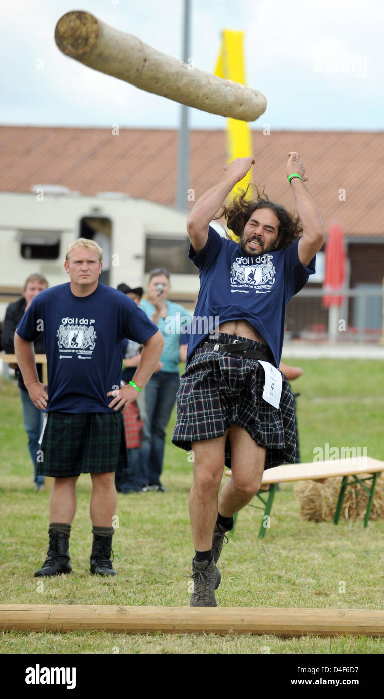 A participant of the Bavarian Highland Games competes in tree trunk ...