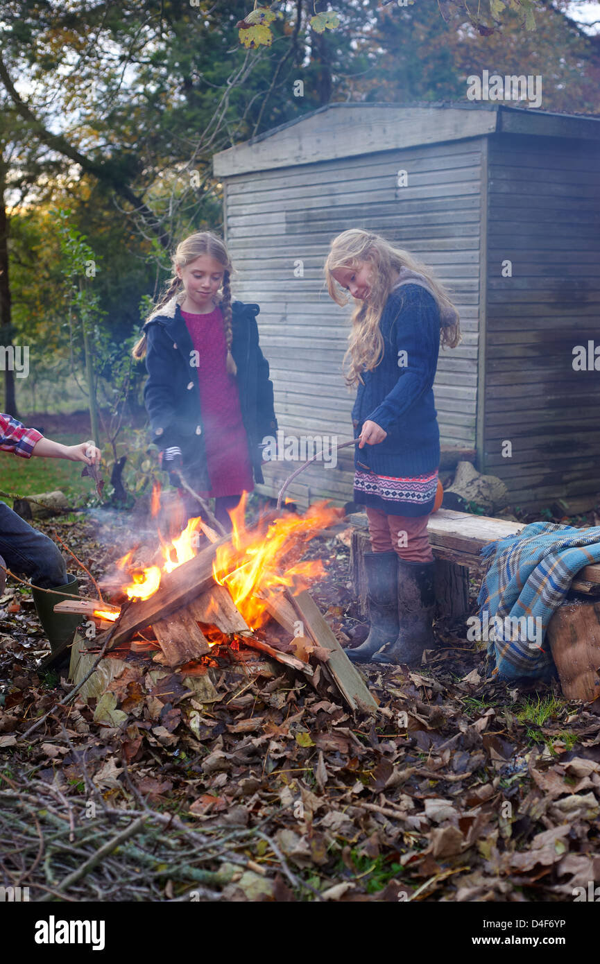 Girls building bonfire outdoors Stock Photo - Alamy