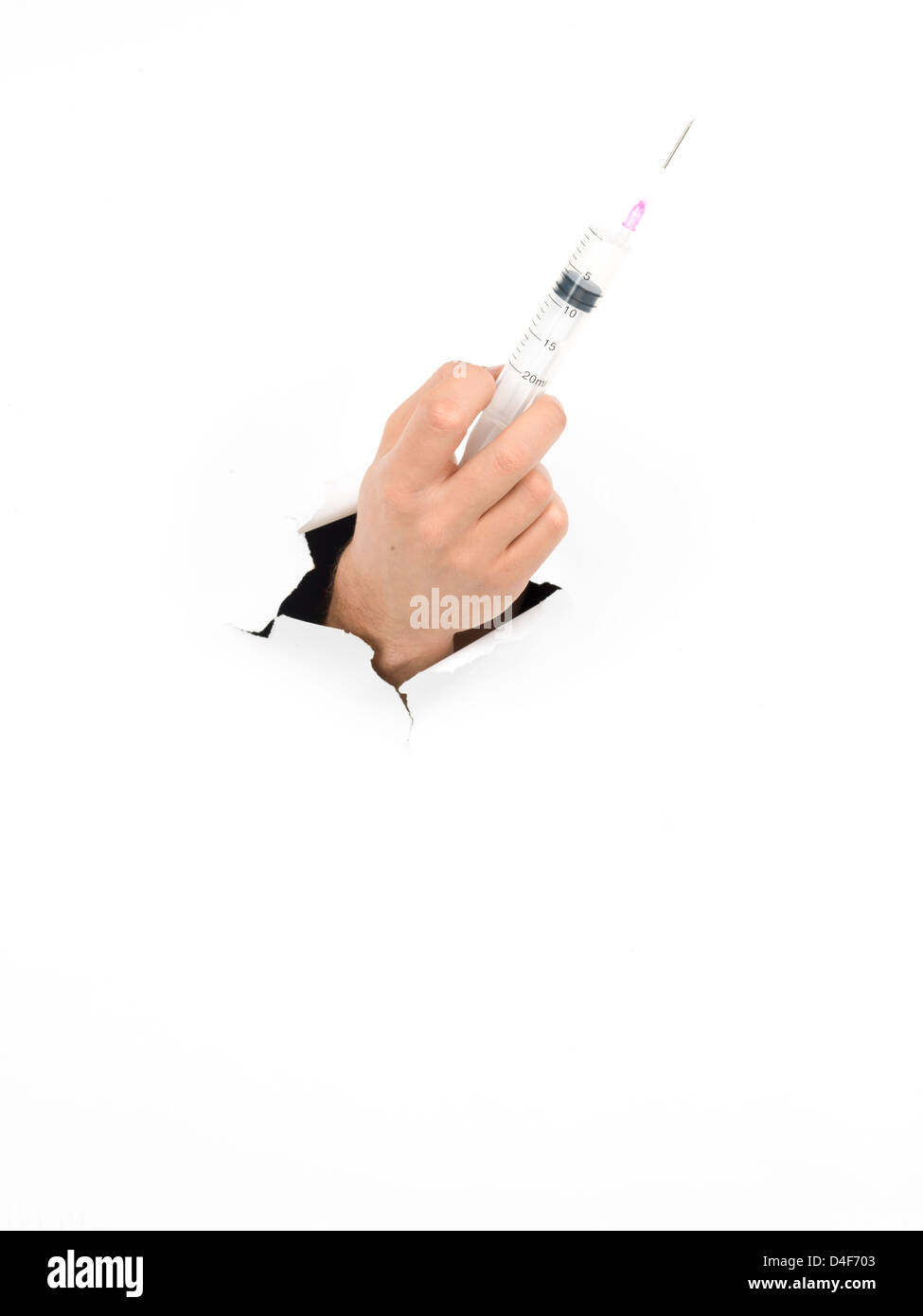 close-up of male hand holding a syringe through a torn white paper ...