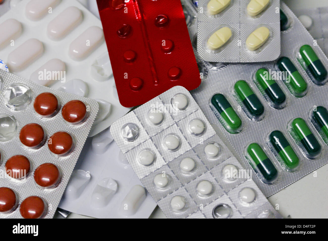 Packed and unpacked pharmaceuticals in various colours, shapes and ...