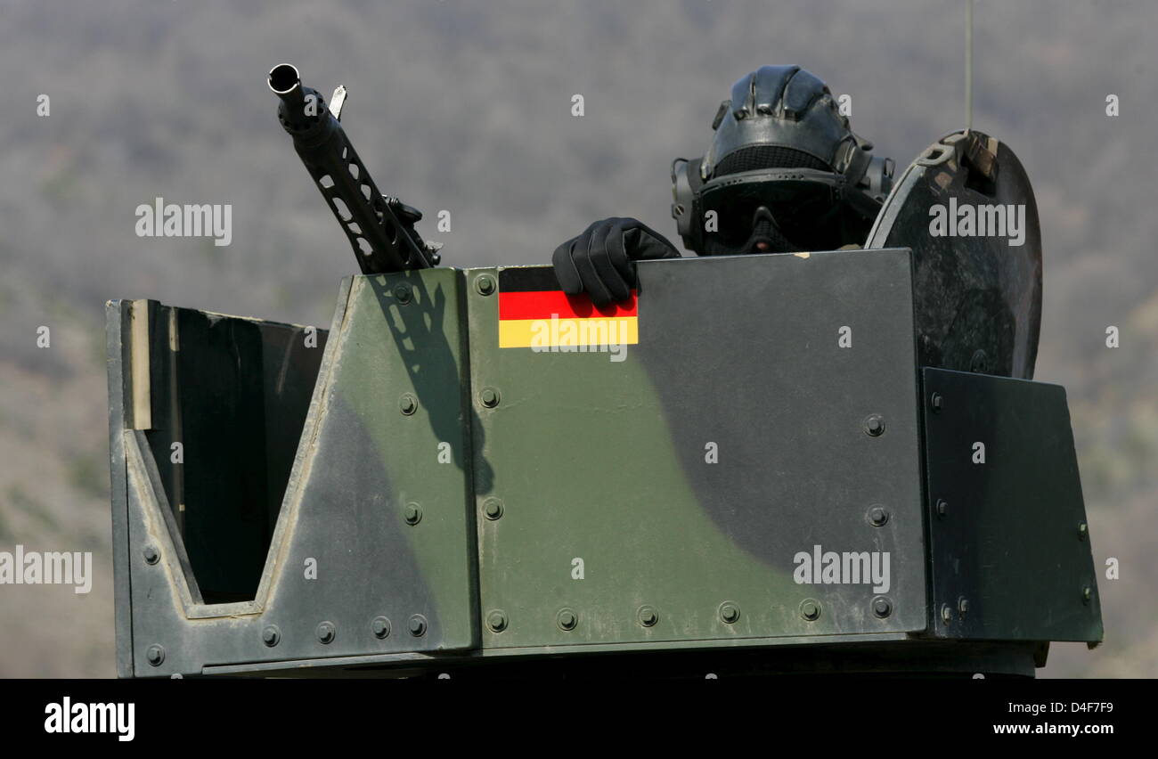 A German Bundeswehr soldier hides with his machine gun on top of an ...