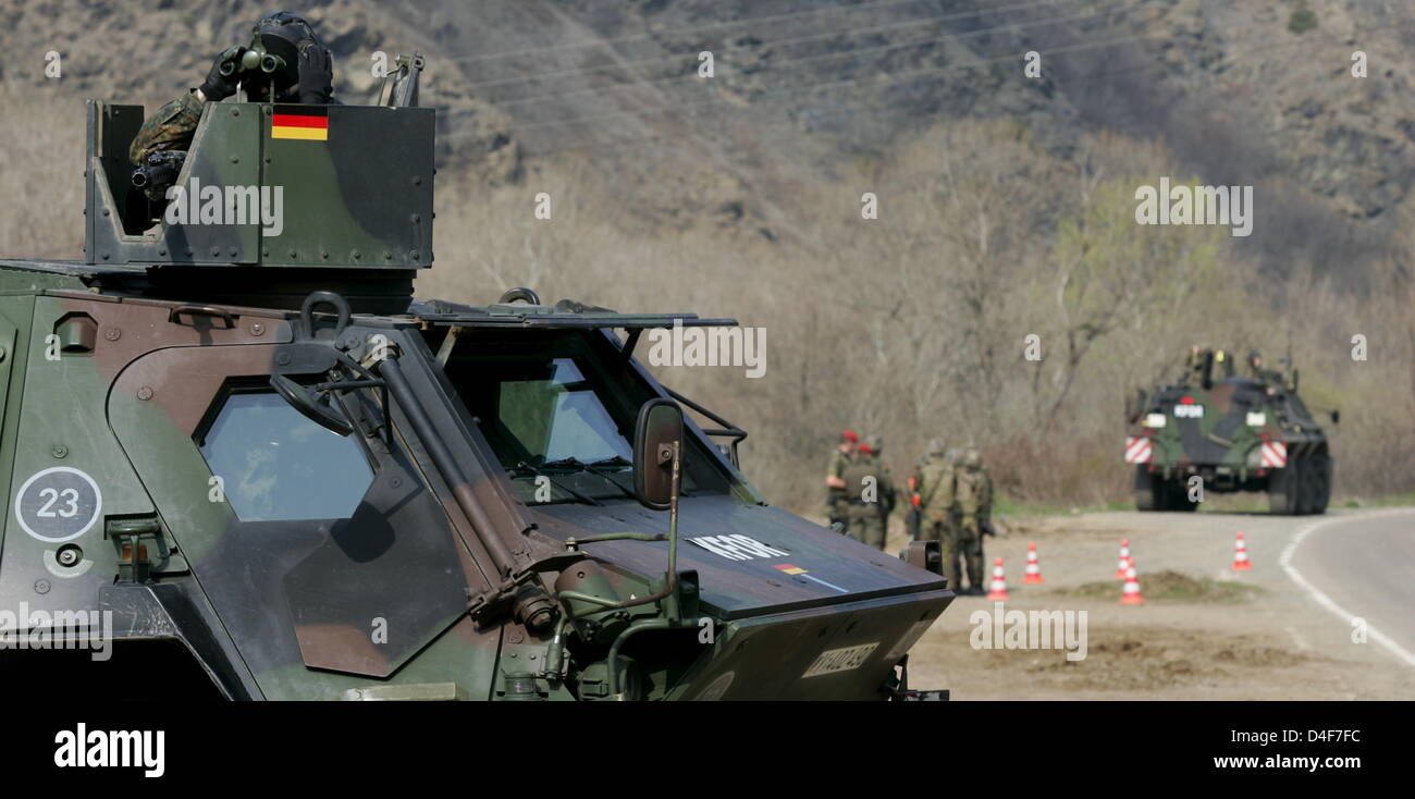 A German Bundeswehr soldier monitors from the top of an armoured ...