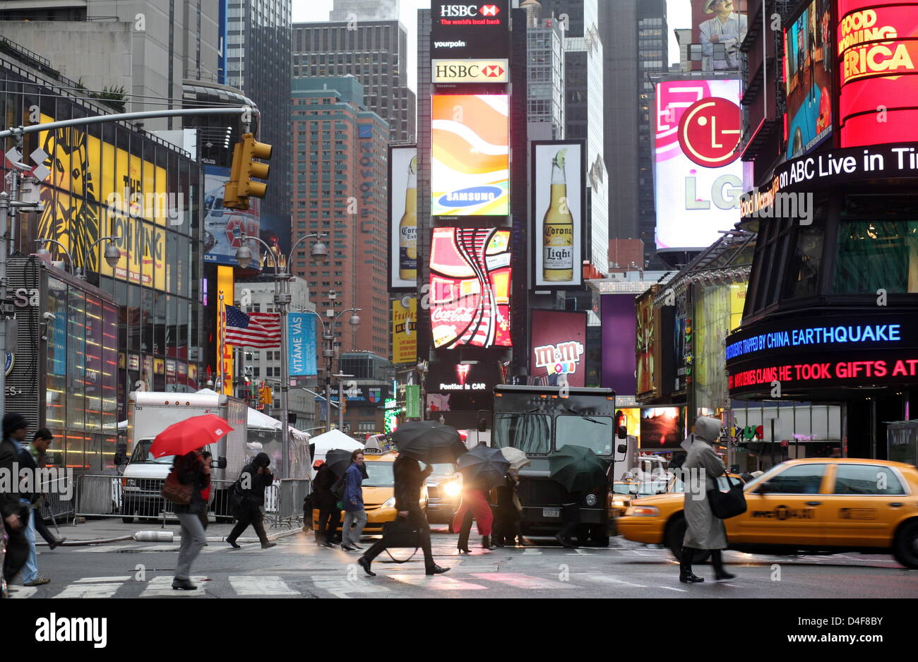 People with umbrellas are pictured on a crosswalk at Time Square in ...