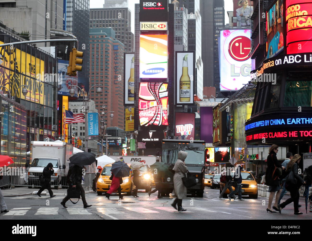 People with umbrellas are pictured on a crosswalk at Time Square in ...