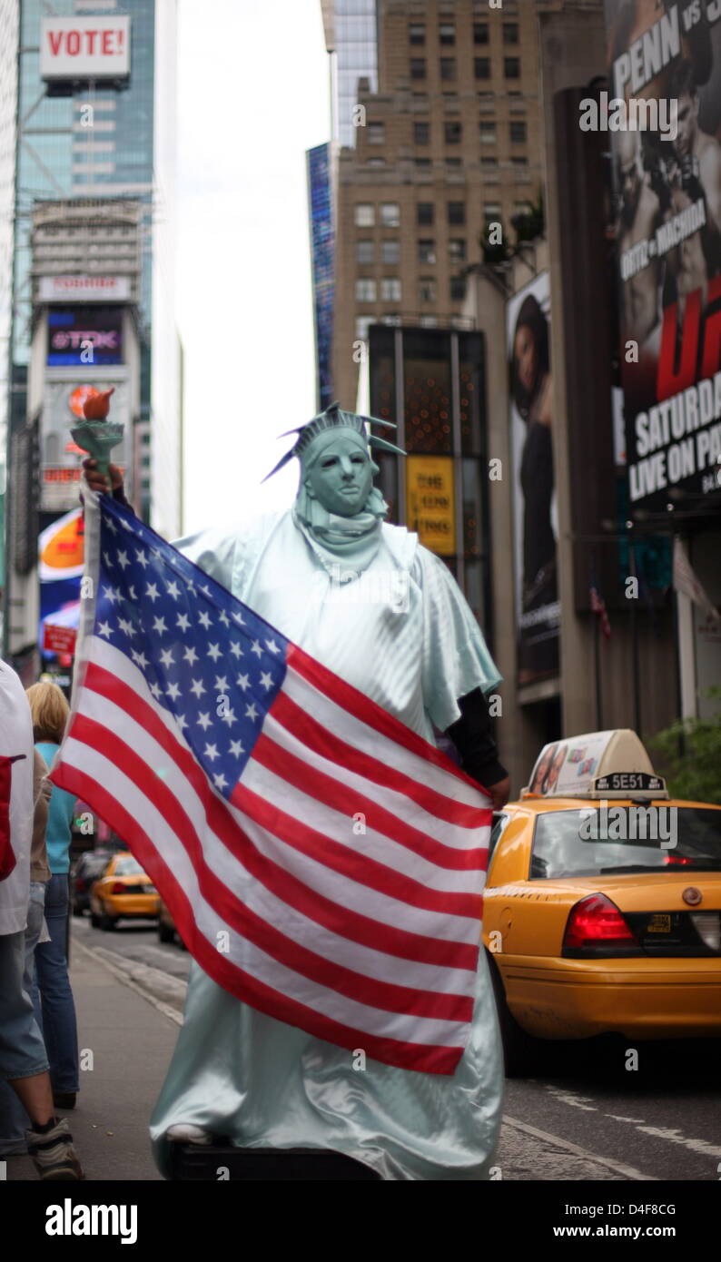 A man dresses up as the Statue of Liberty poses with the American flag ...
