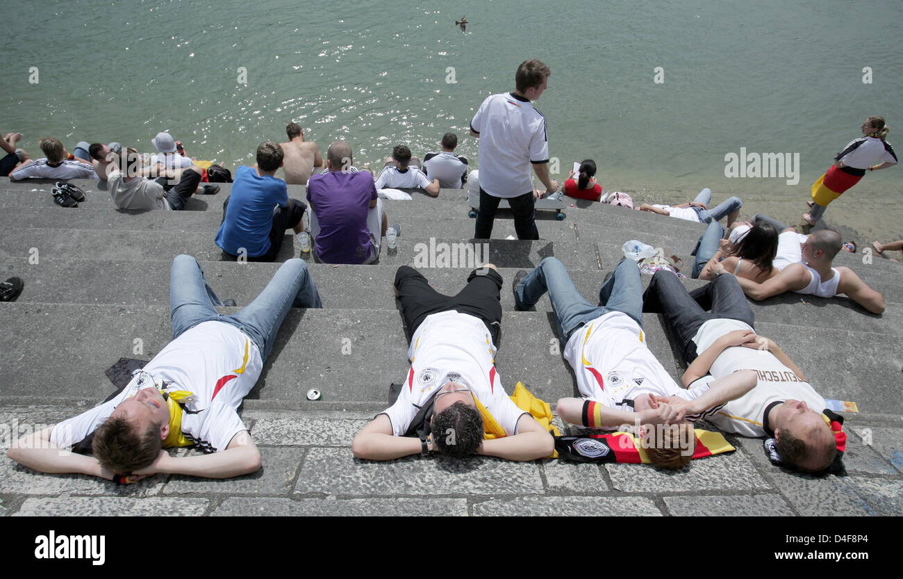 German Supporters sunbathing at the banks of the river rhine, downtown ...