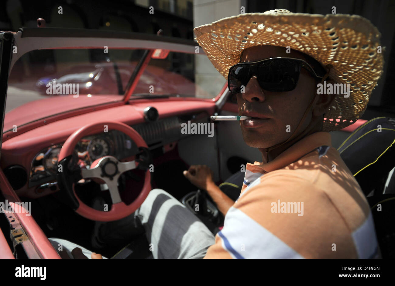 March 12, 2013 - Havana, Cuba - Alex Perri poses for a portrait in his pink Cadillac used as a ...