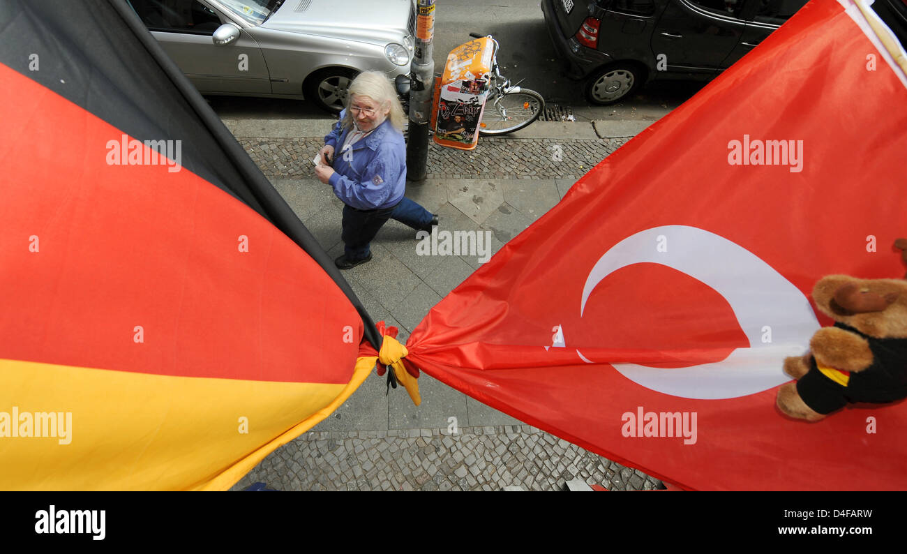 German and Turkish flags tied together are pictured in front of a kiosk ...