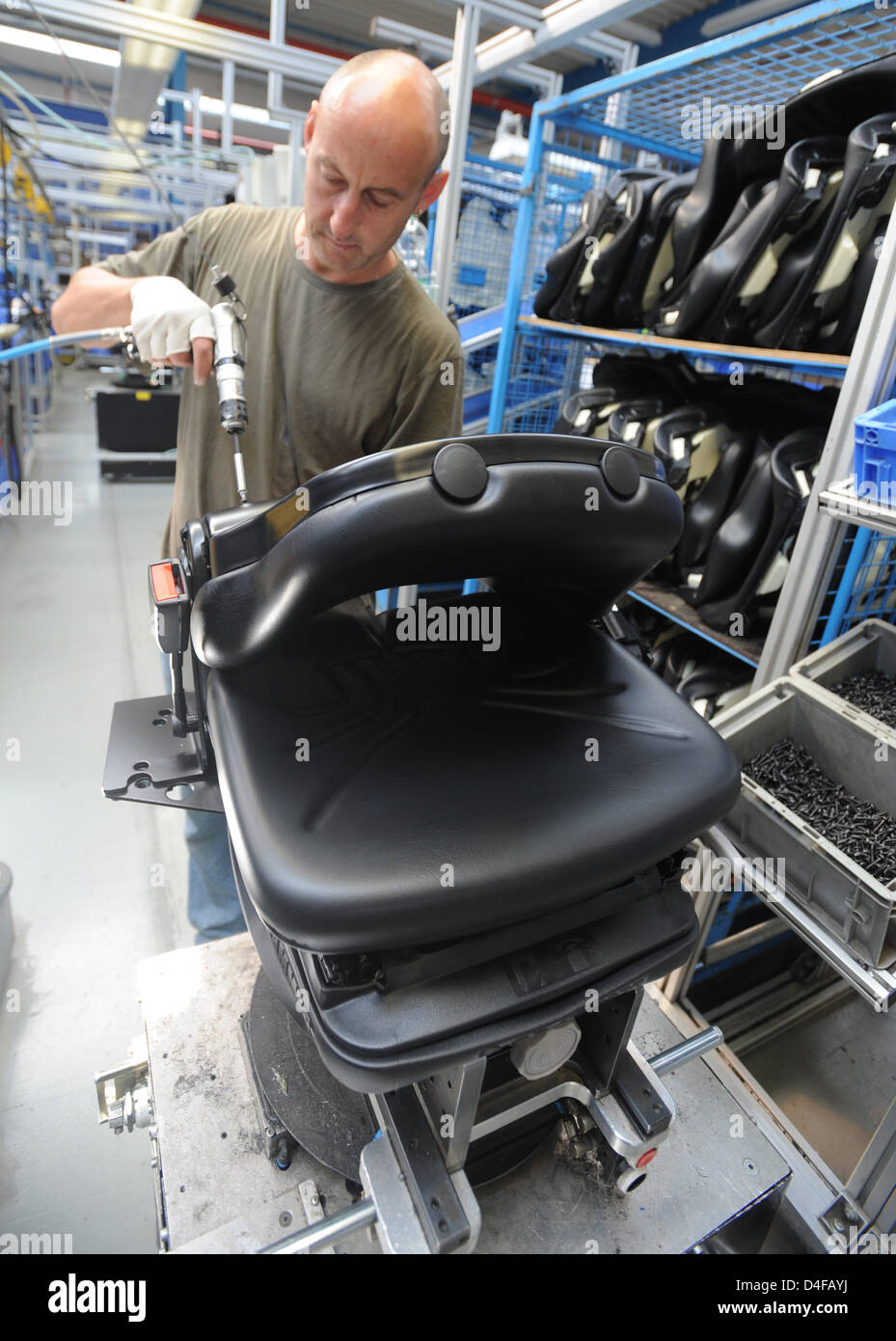 An employee of car supplier Grammer assembles a vehicle seat at the ...