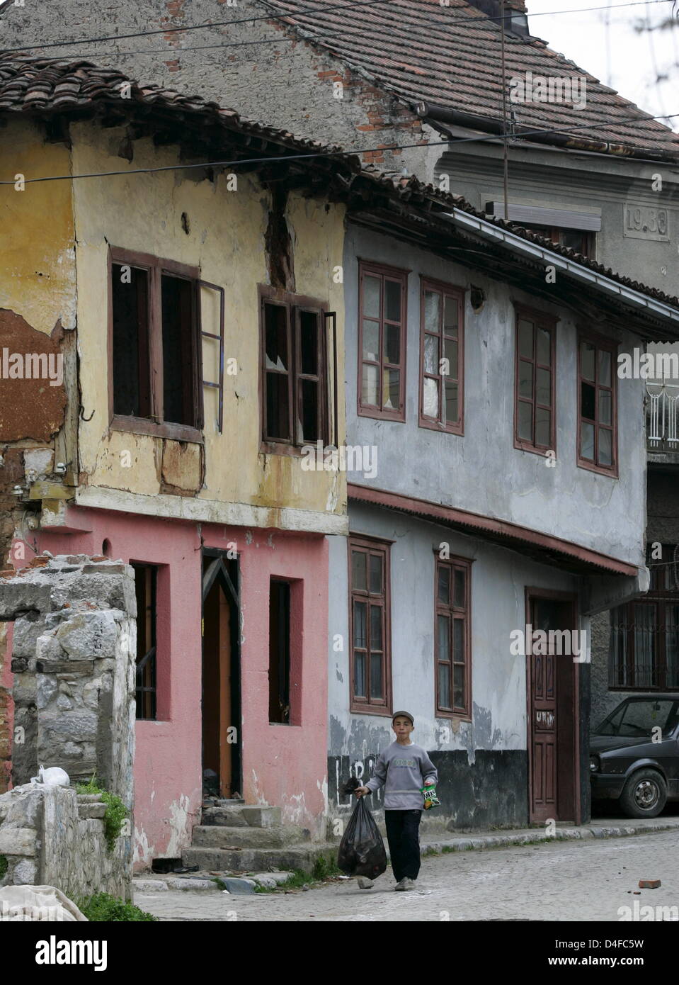 A boy walks down a street in the party destroyed and still closed off ...