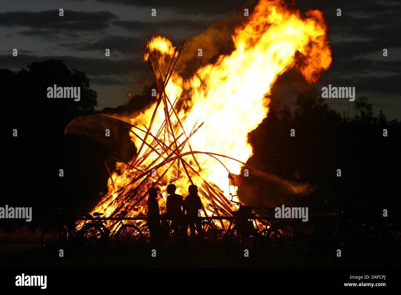 Three lads watch the Midsummer Night bonfire in Dettelbach, Germany, 28 ...