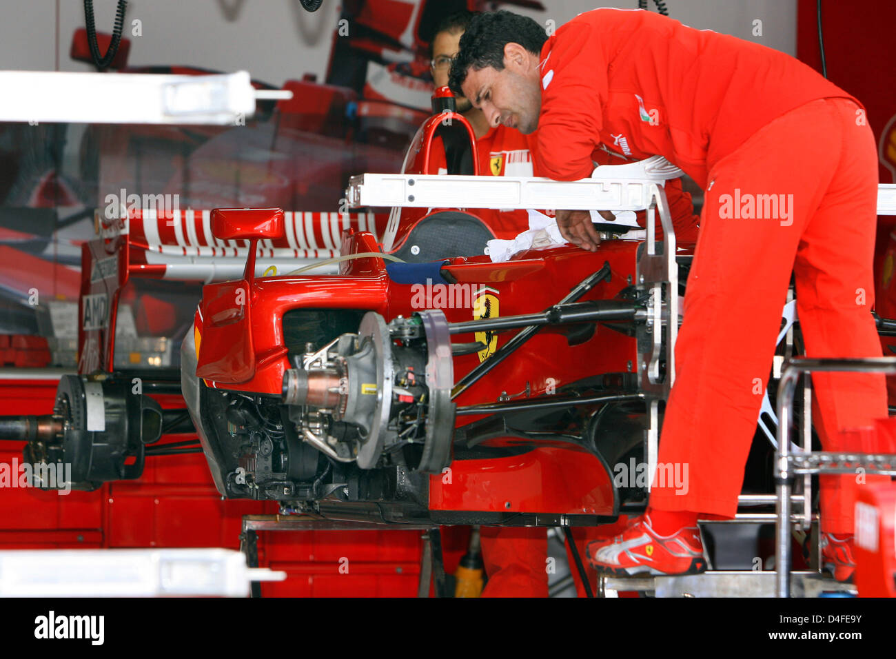 A mechanic of the Ferrari team works in the pit at the Silverstone race ...