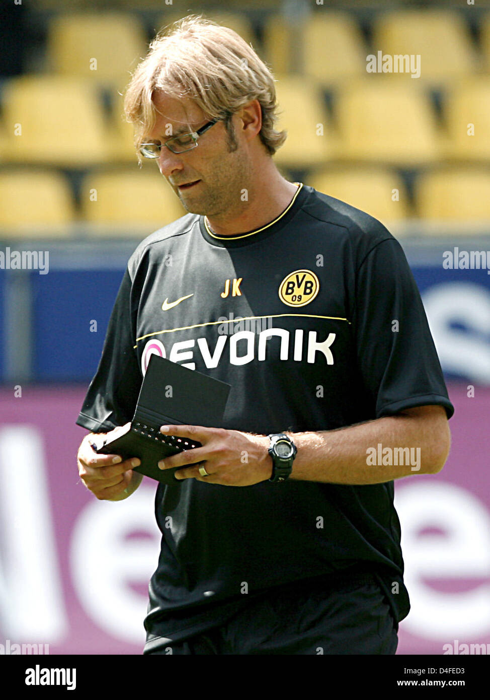 The new coach of Borussia Dortmund Juergen Klopp holds a notepad during ...