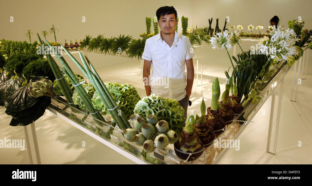Japanese artist Makoto Azuma stand in a flower installation at the ...