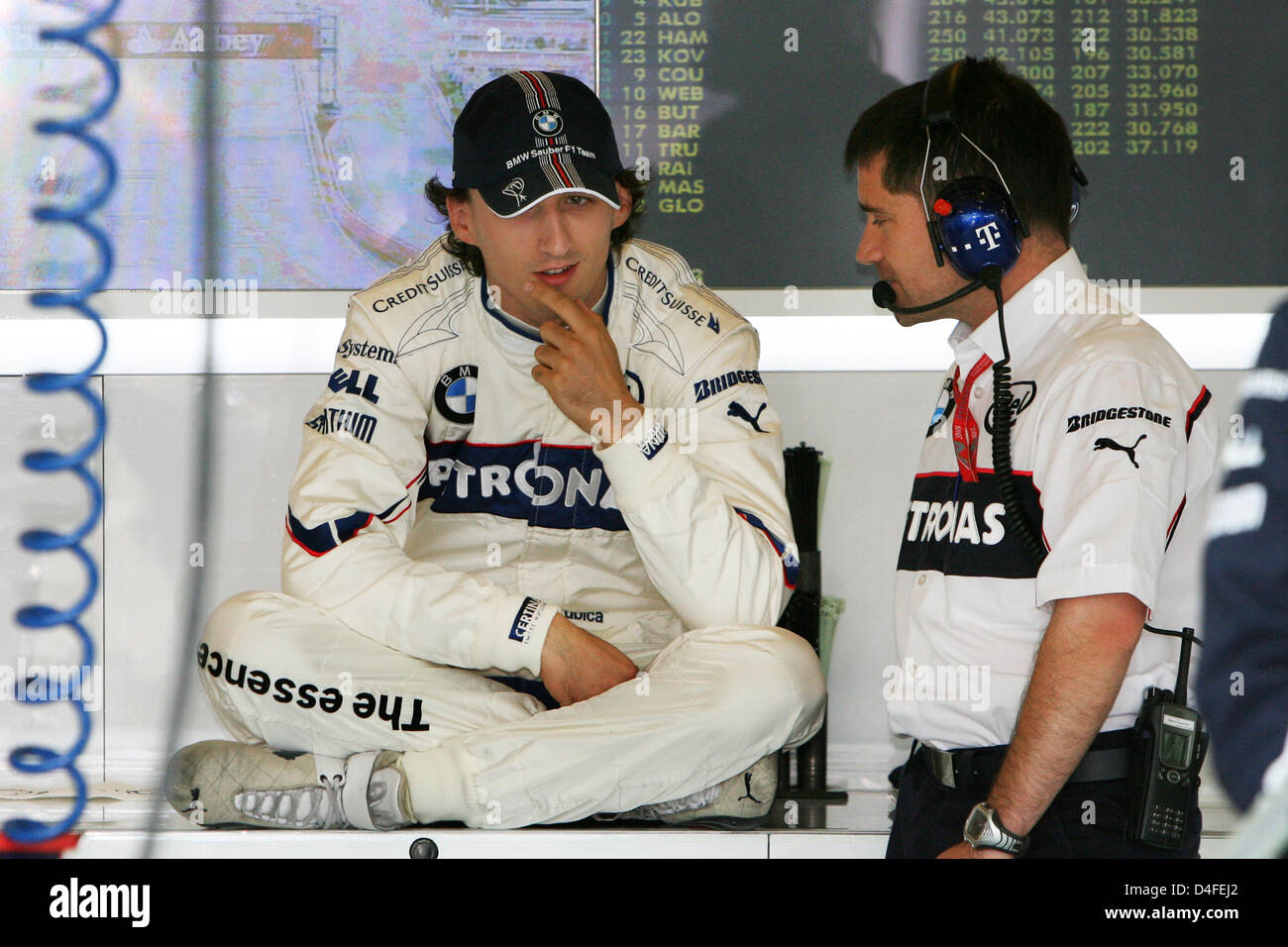 Polish Formula One driver Robert Kubica (L) of BMW Sauber talks to a ...