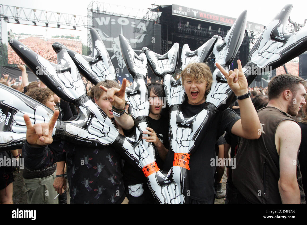 Heavy metal fans pose with air cushions in form of the metal greeting ...