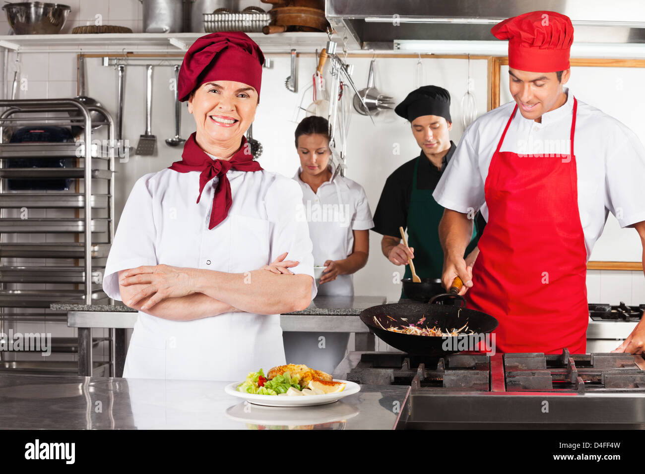 Female Chef With Arms Crossed In Kitchen Stock Photo - Alamy