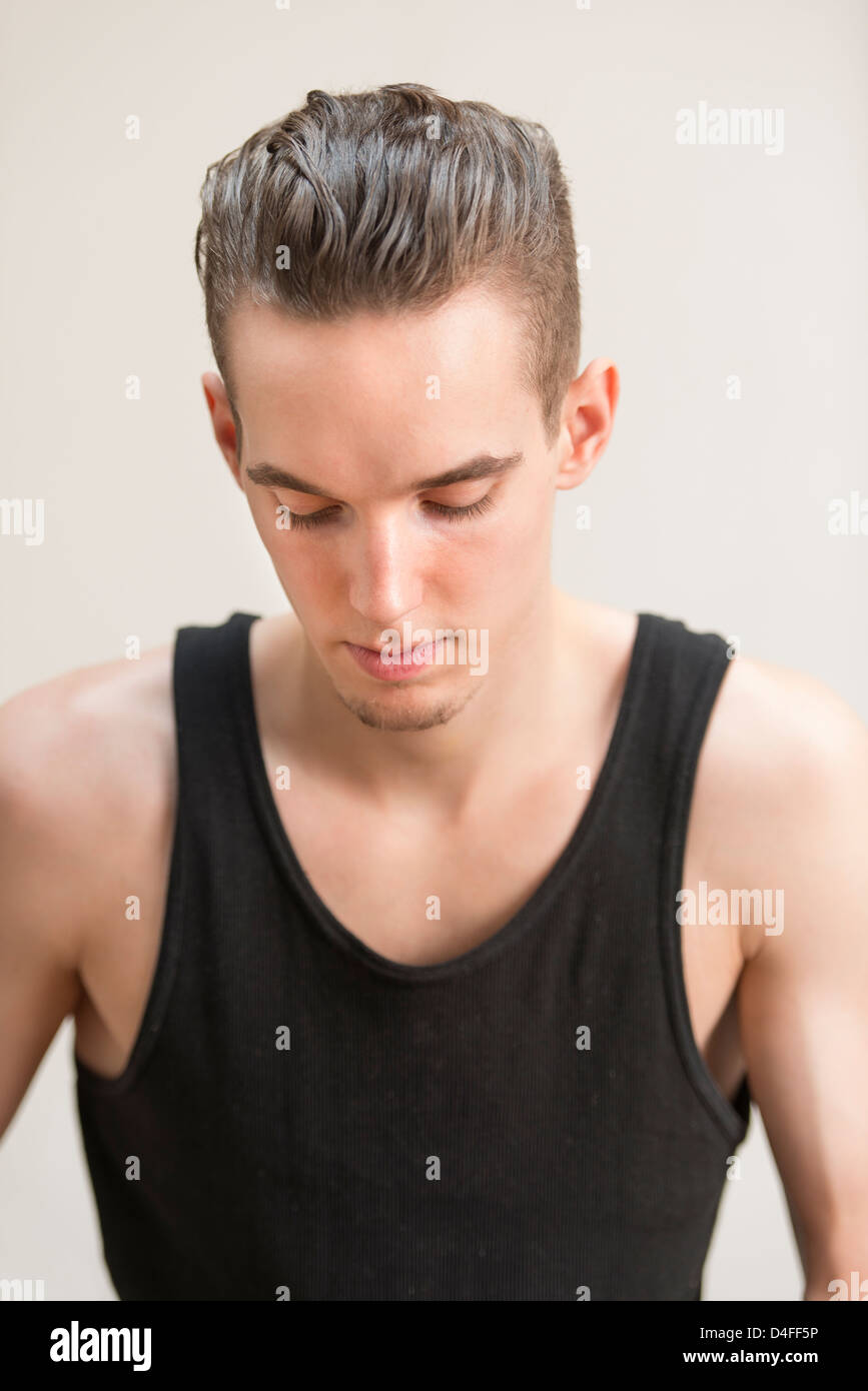 Thoughtful young adult man looking down with pensive expression Stock ...