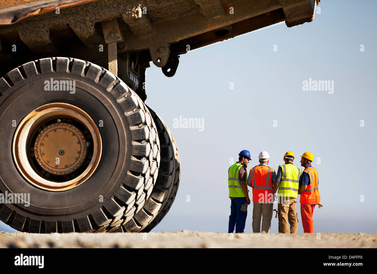 Workers talking by machinery on site Stock Photo - Alamy