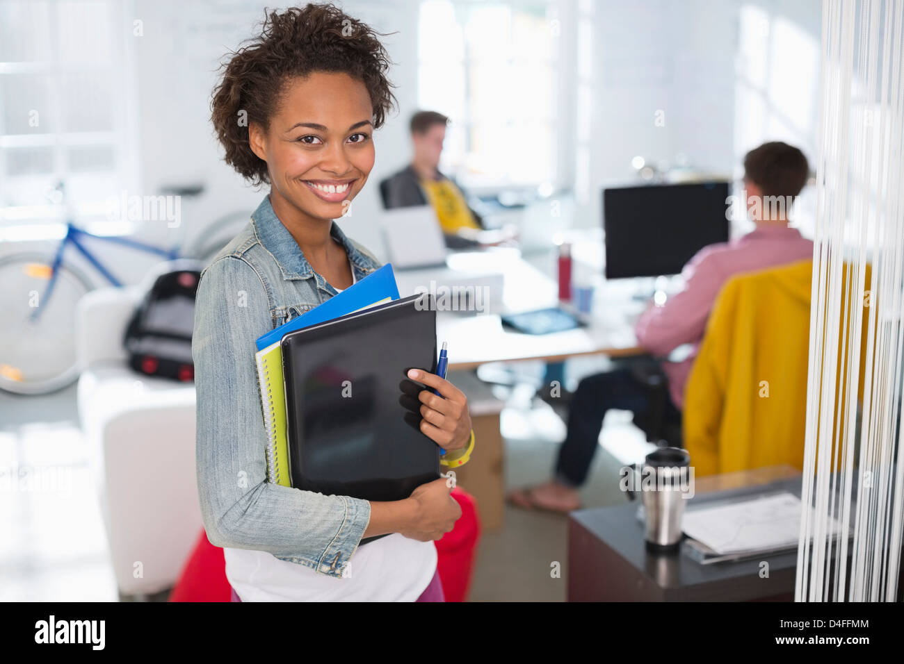 Businesswoman carrying laptop in office Stock Photo - Alamy