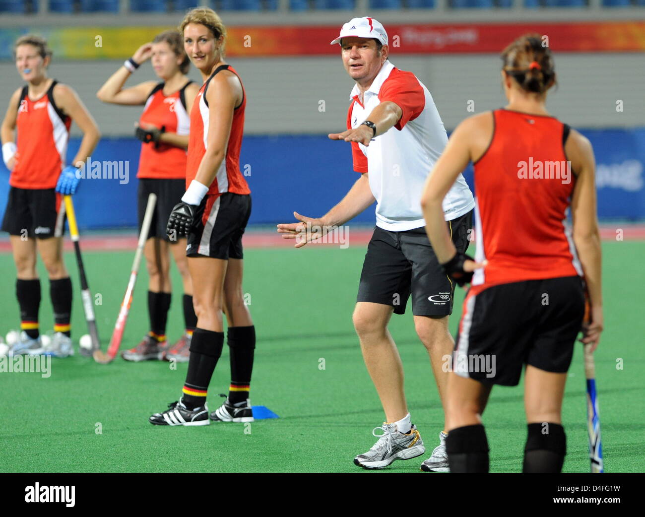 Coach of Germany's women's hockey team, Michael Behrmann (2-R) is ...