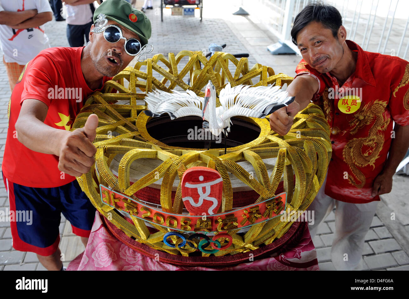 Chinese fans pose with a home-made model of the National Stadium prior ...