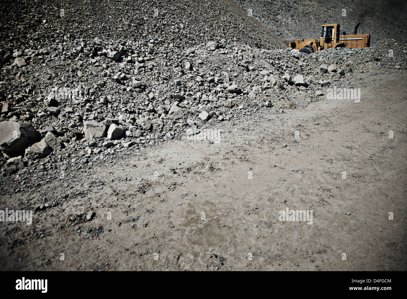 Digger driving in quarry Stock Photo - Alamy