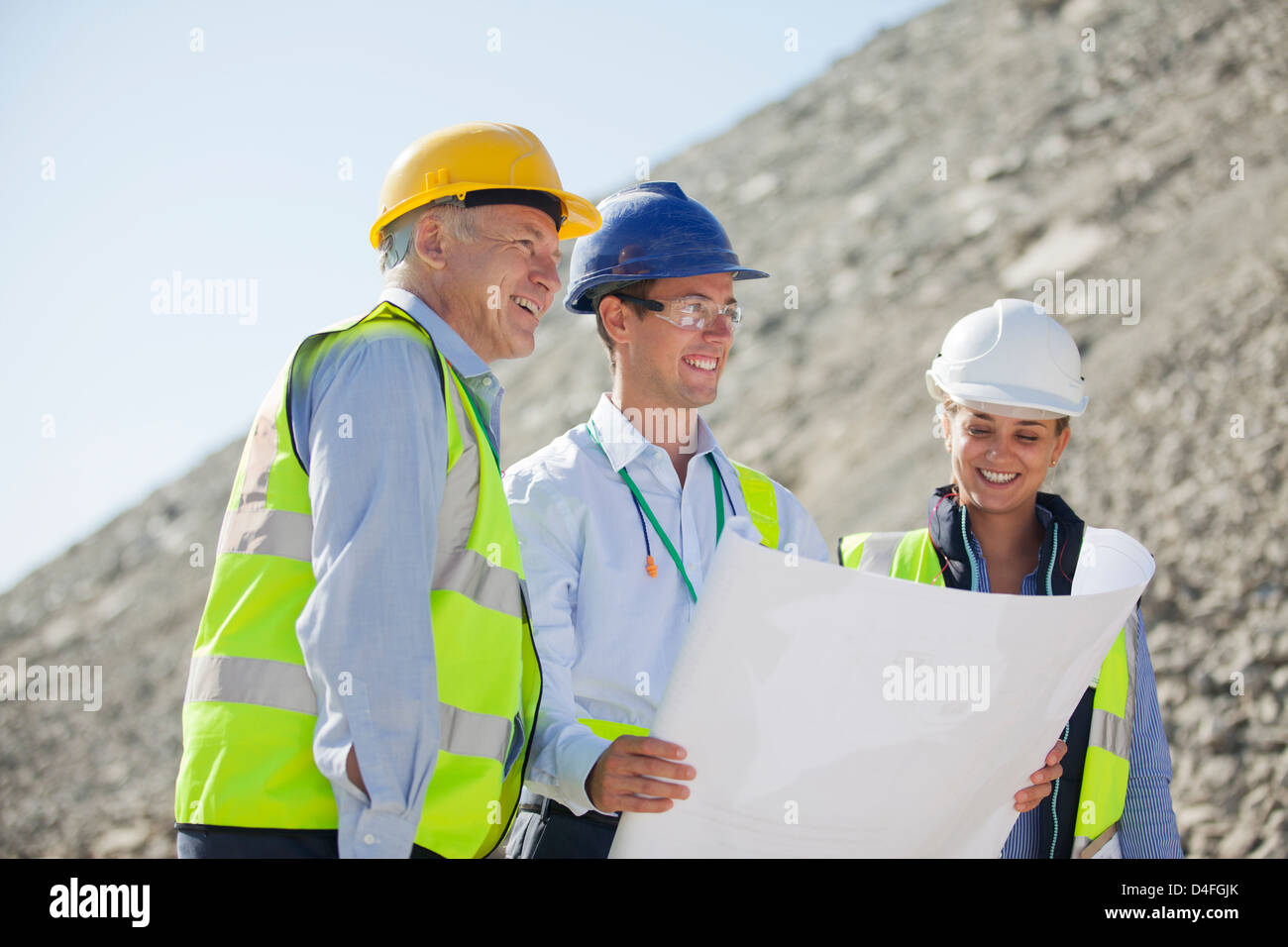 Business people reading blueprints in quarry Stock Photo - Alamy