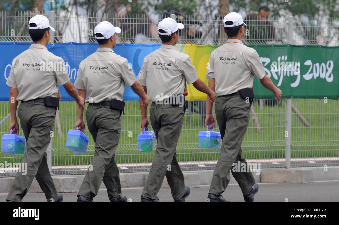 Chinese security march in formation carrying a blue plastic container ...