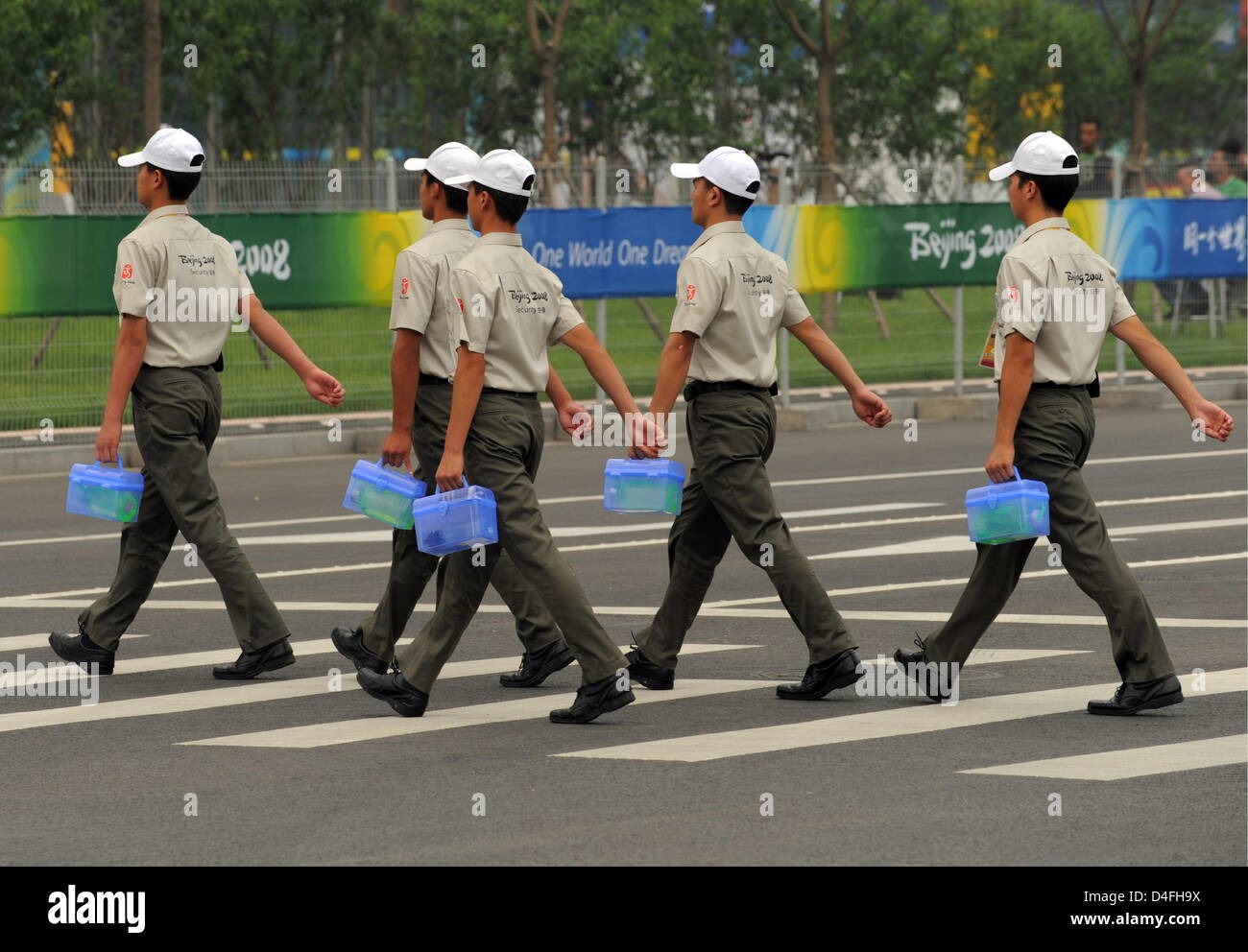 Chinese security march in formation carrying a blue plastic container ...
