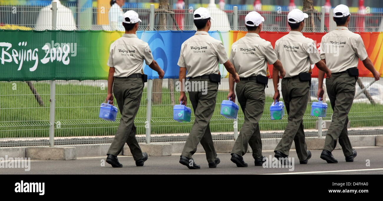 Chinese security march in formation carrying a blue plastic container ...