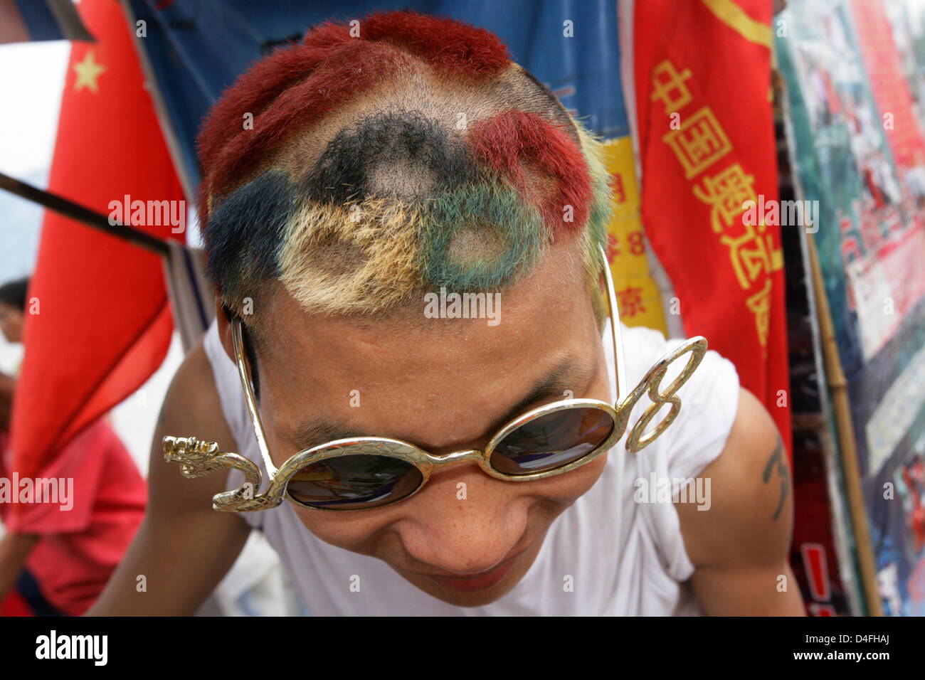 A Chinese man shows his hair cut cut into the Olympic rings in Beijing ...