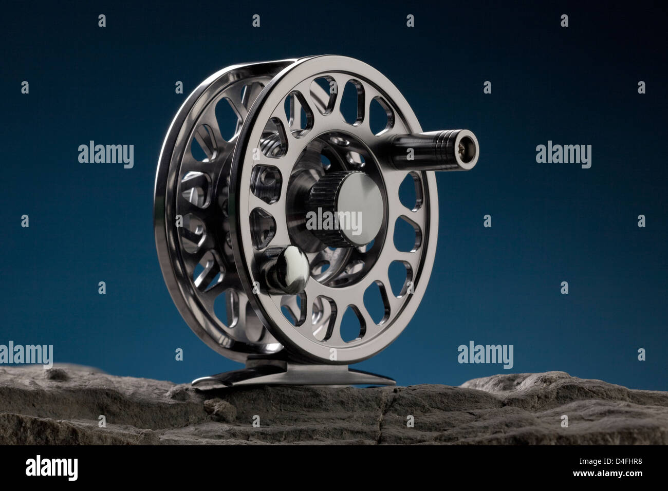 reel fishing rod on a blue background Stock Photo - Alamy