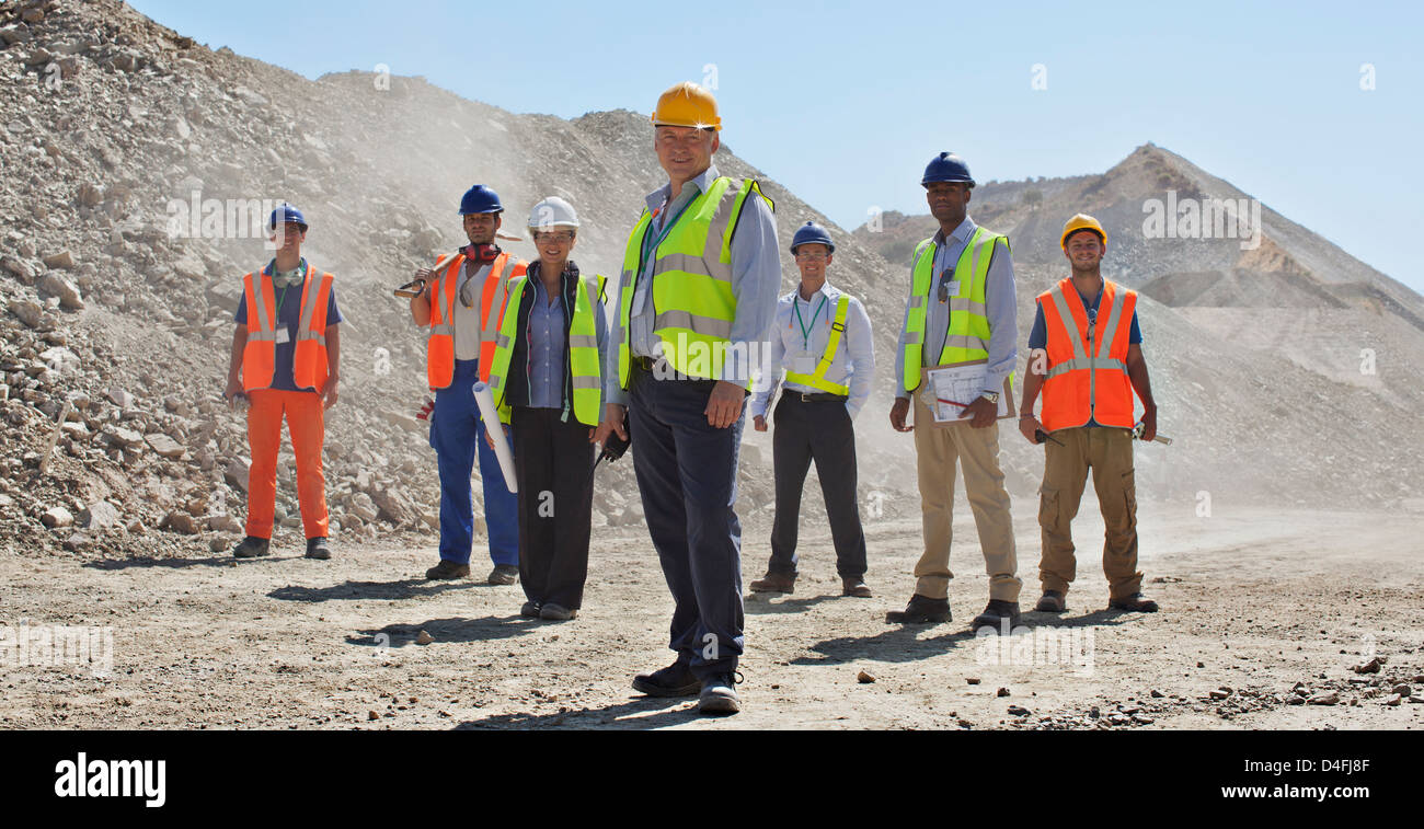 Business people and workers standing in quarry Stock Photo - Alamy