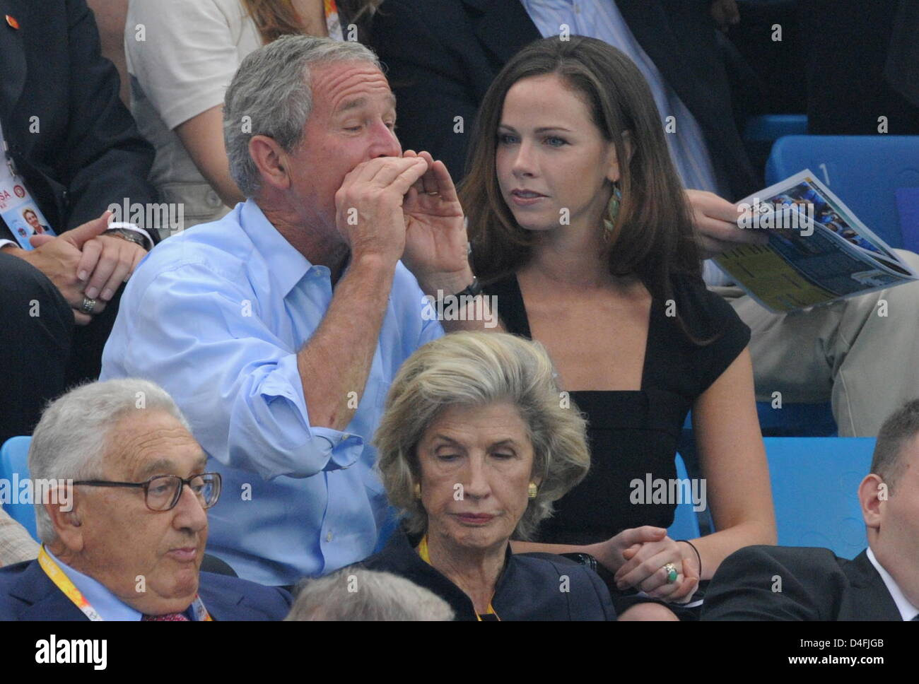 US president George W. Bush cheers while he watches US swimmer Michael ...