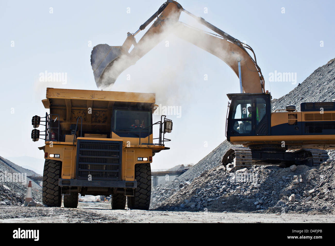 Digger and truck working in quarry Stock Photo - Alamy