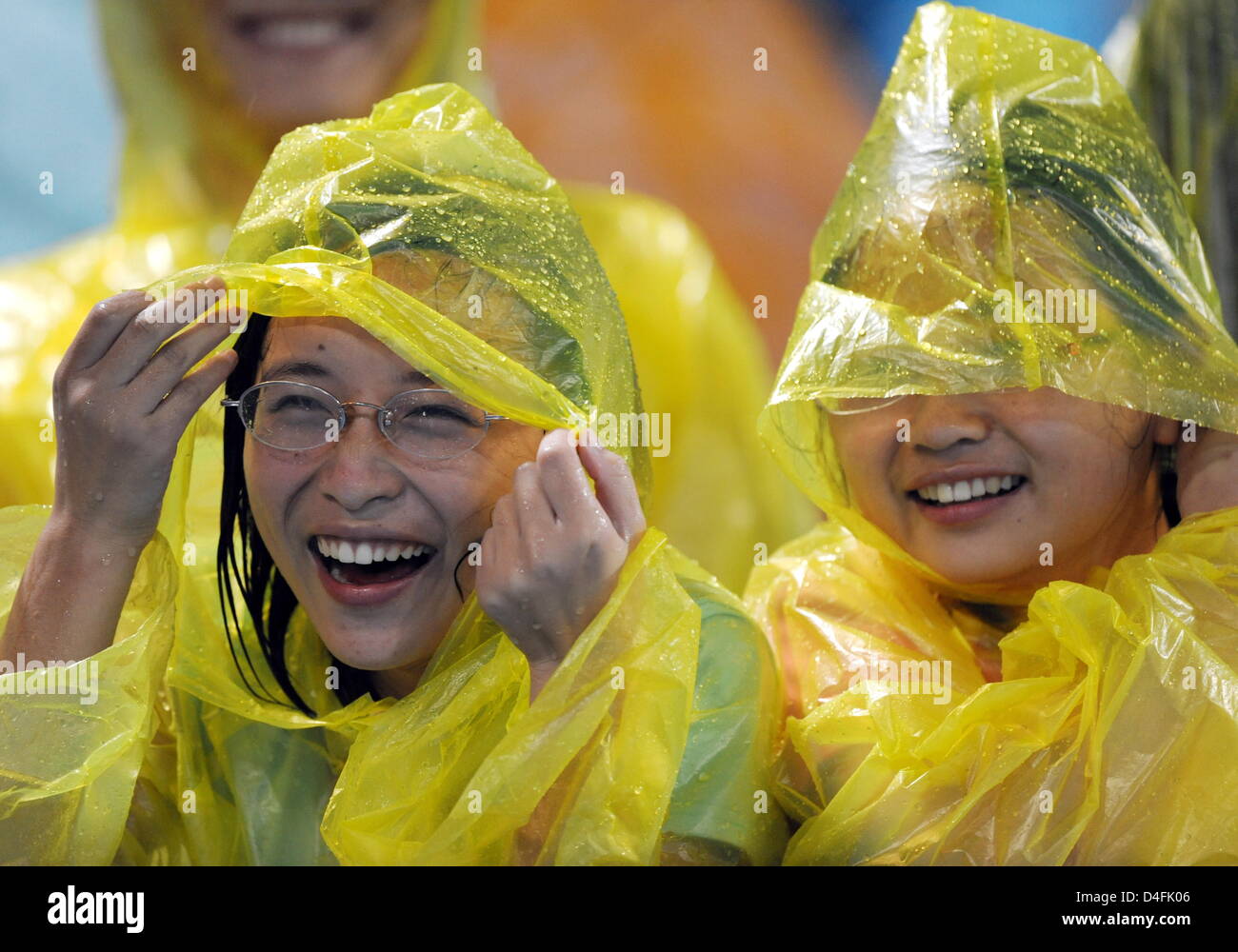 Spectators with raincoats are pictured in the womenÒs field hockey ...
