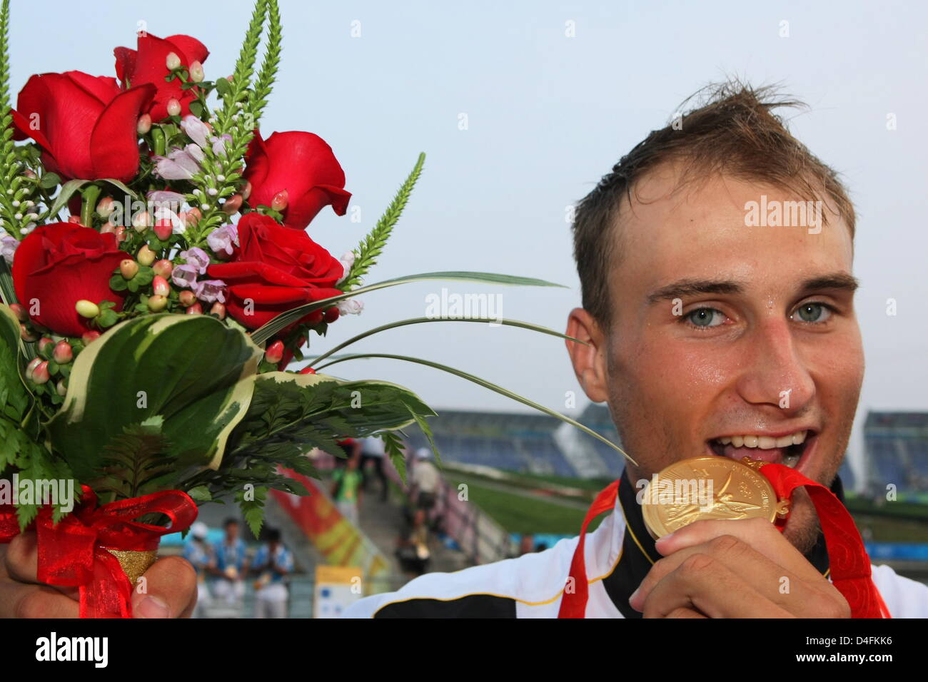 German Alexander Grimm bites his goldmedal on the podium after winning ...
