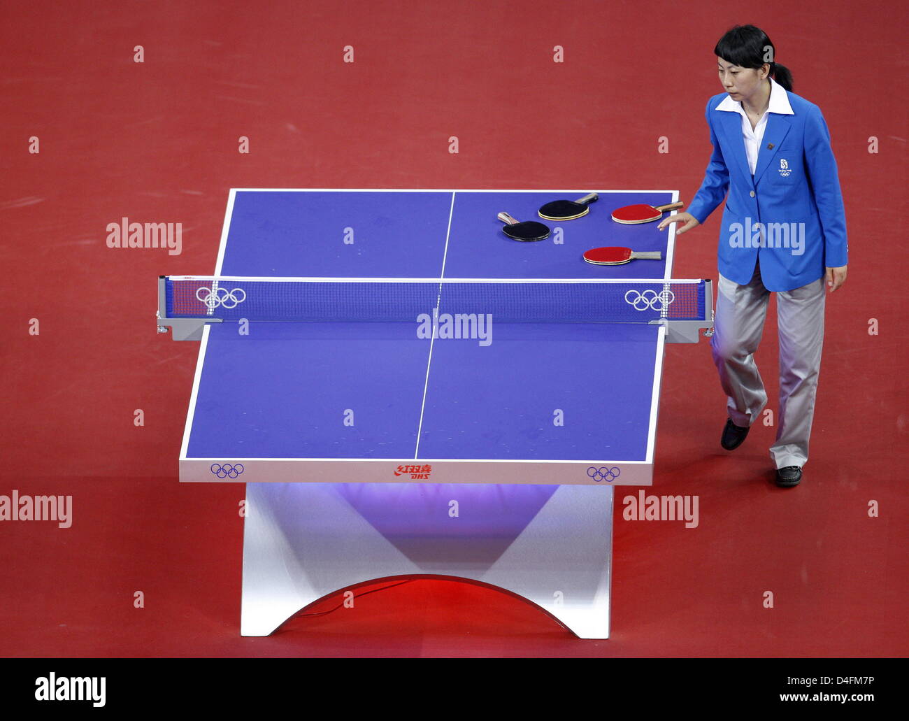 A referee checks the table during the womenÒs team table tennis ...