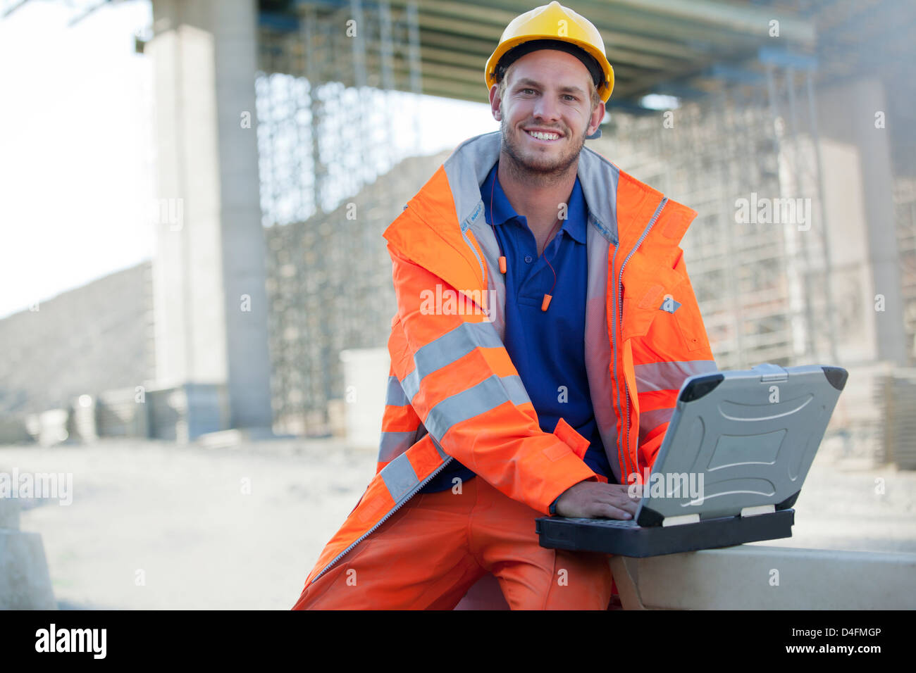 Worker using laptop on site Stock Photo - Alamy