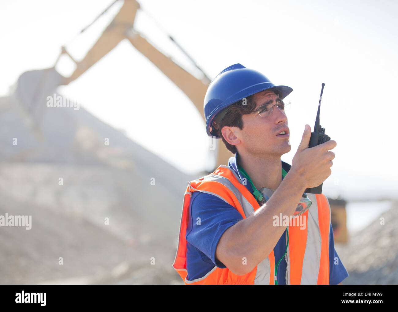 Worker using walkie-talkie in quarry Stock Photo - Alamy