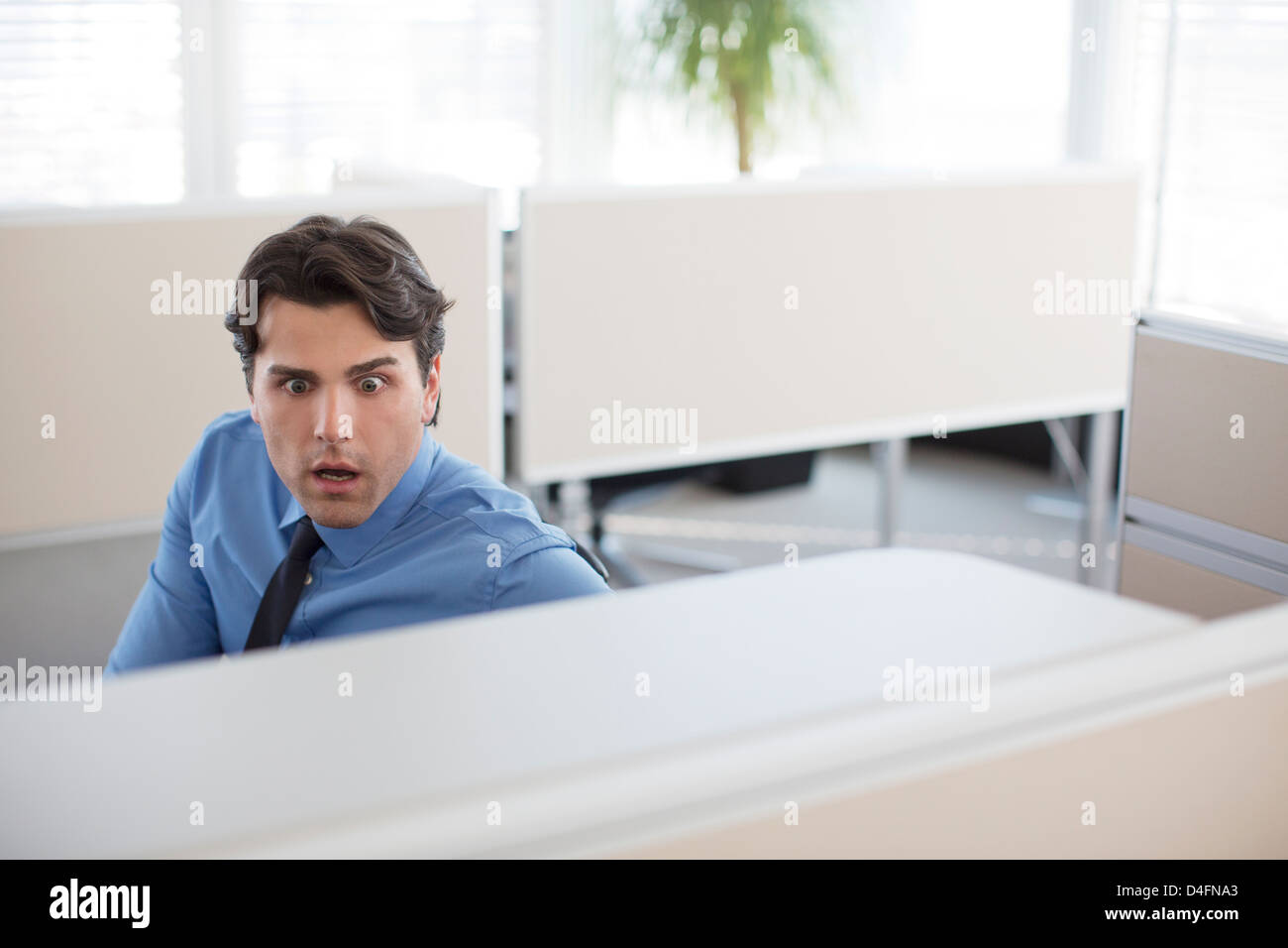 Surprised businessman working in office Stock Photo - Alamy