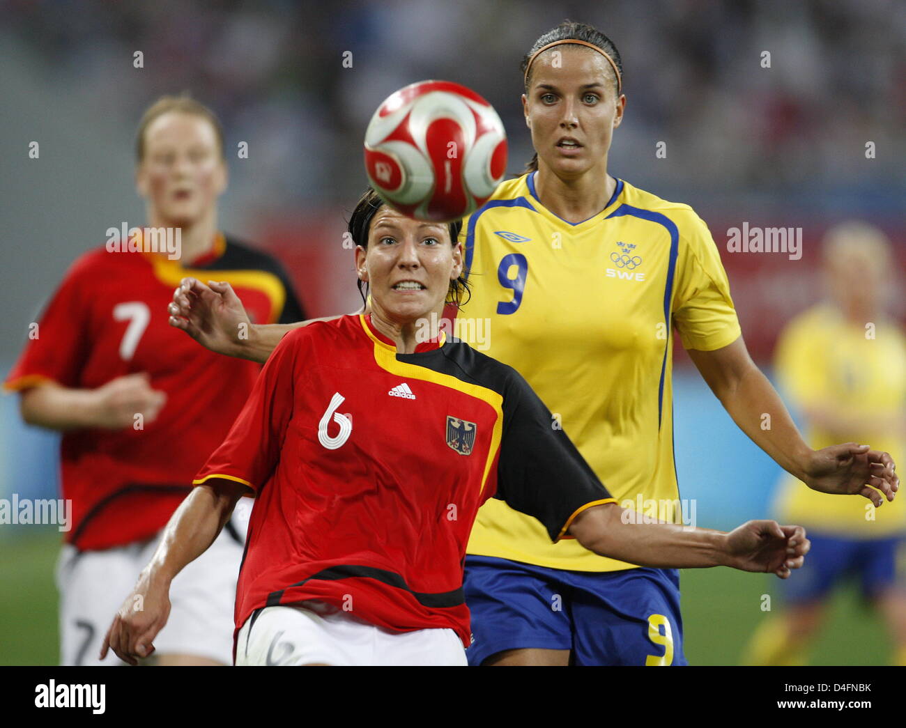 Linda Bresonik (C) of Germany vies with Jessica Landstrom (R) of Sweden ...